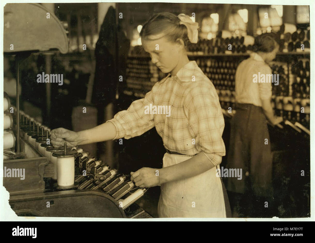 This photograph shows a spooler tender at the Berkshire Cotton Mills ...