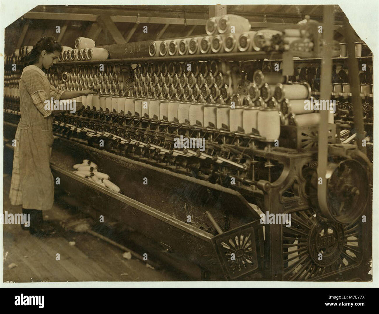 A historical image of a spooler tender at the American Linen Co ...
