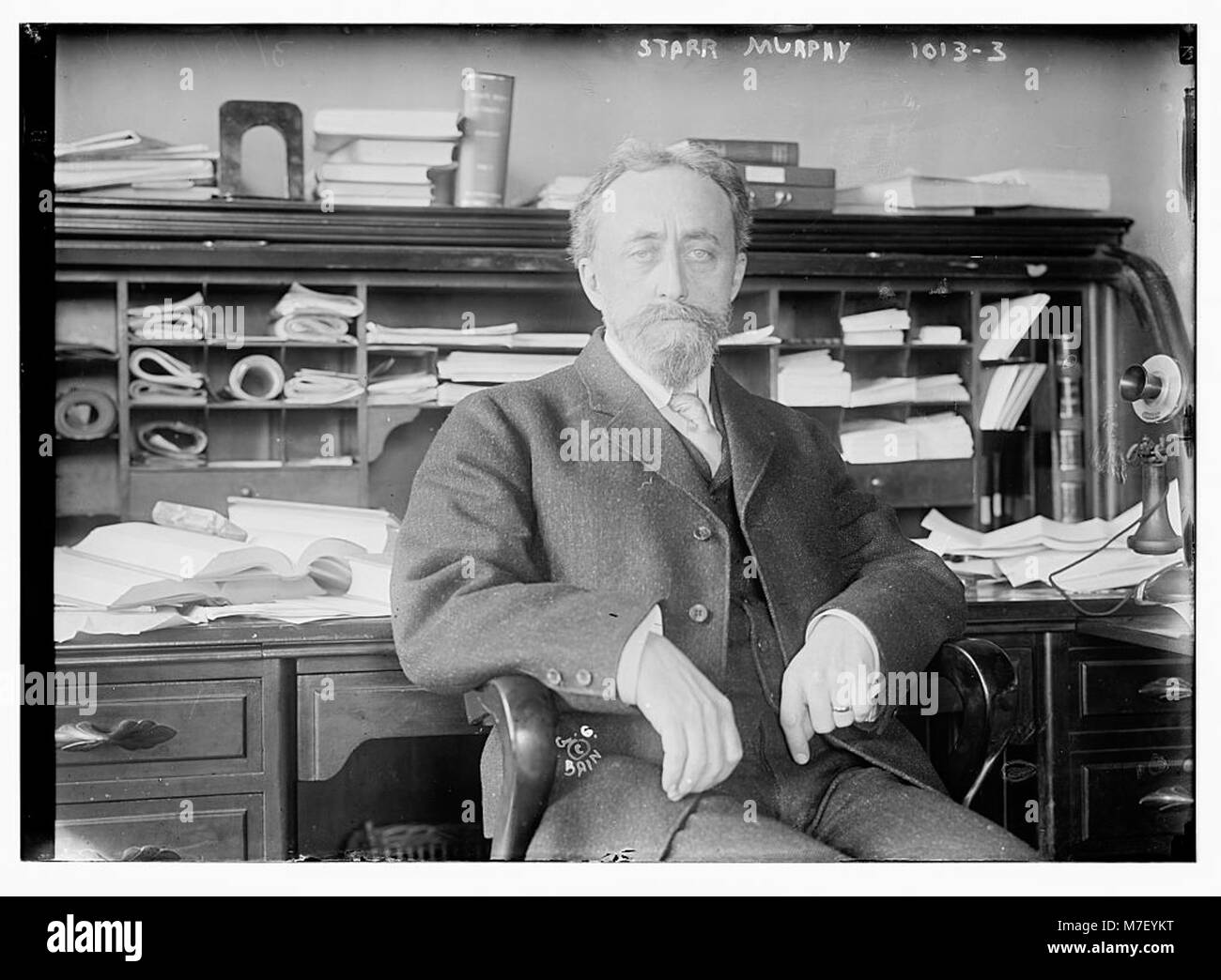 A historical photograph of Starr Murphy seated at a desk, captured in a ...