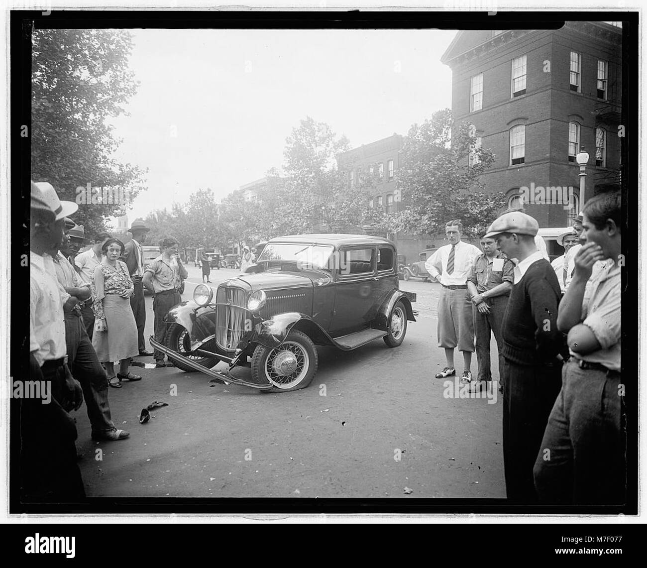This photograph depicts a street scene following an automobile accident ...