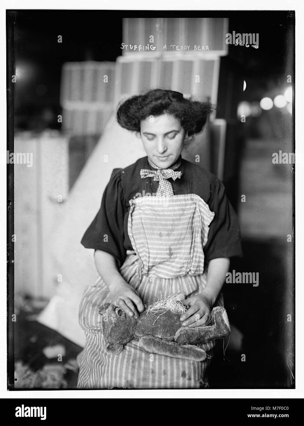 A scene depicting a worker stuffing a teddy bear, capturing the ...