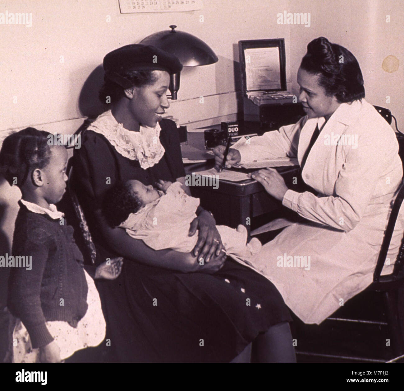 A photograph depicting a medical professional taking a patient's ...