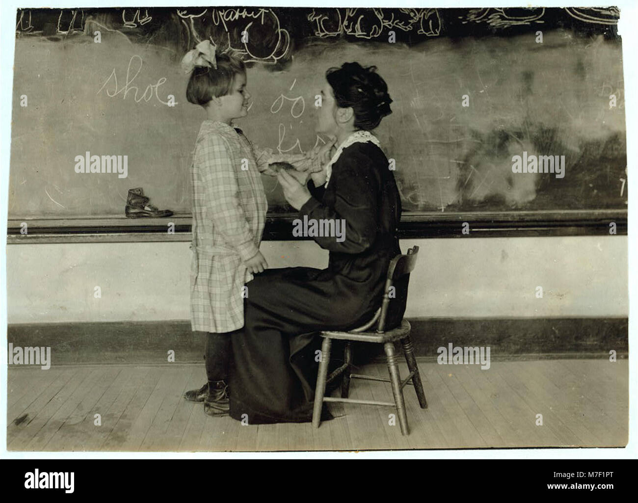 A photograph depicting the process of teaching a deaf-mute to speak at ...