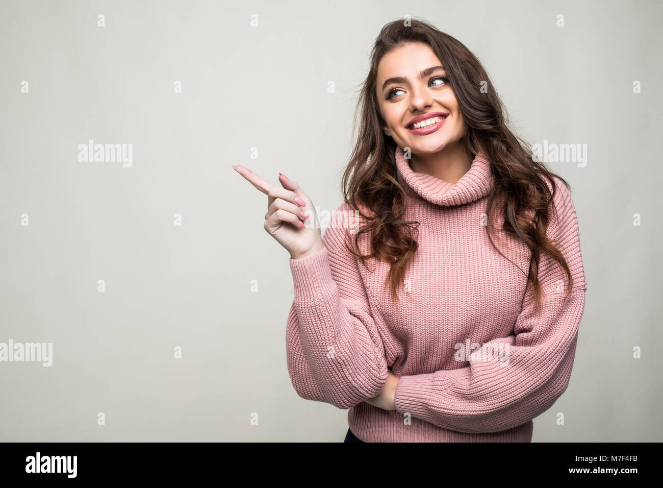 Smiling woman pointing finger side. Isolated portrait on white Stock ...