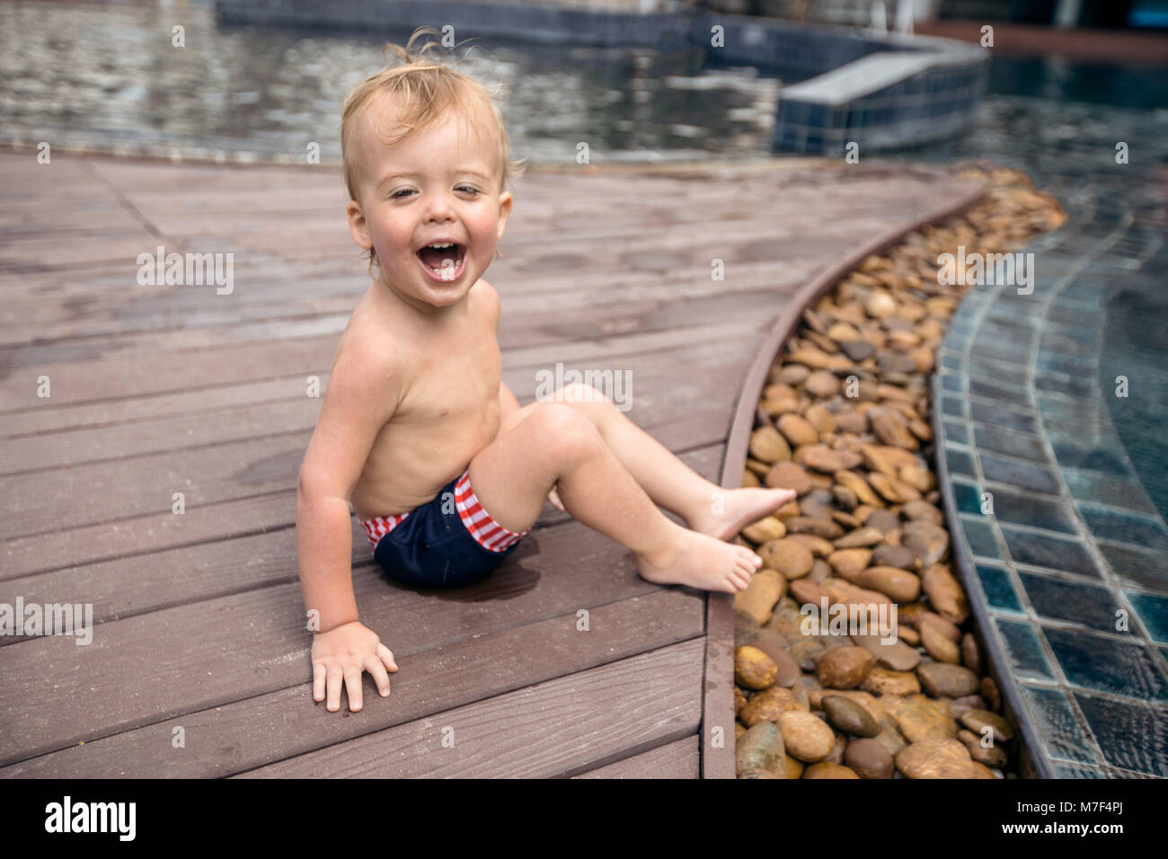Little boy laughing on poolside Stock Photo - Alamy