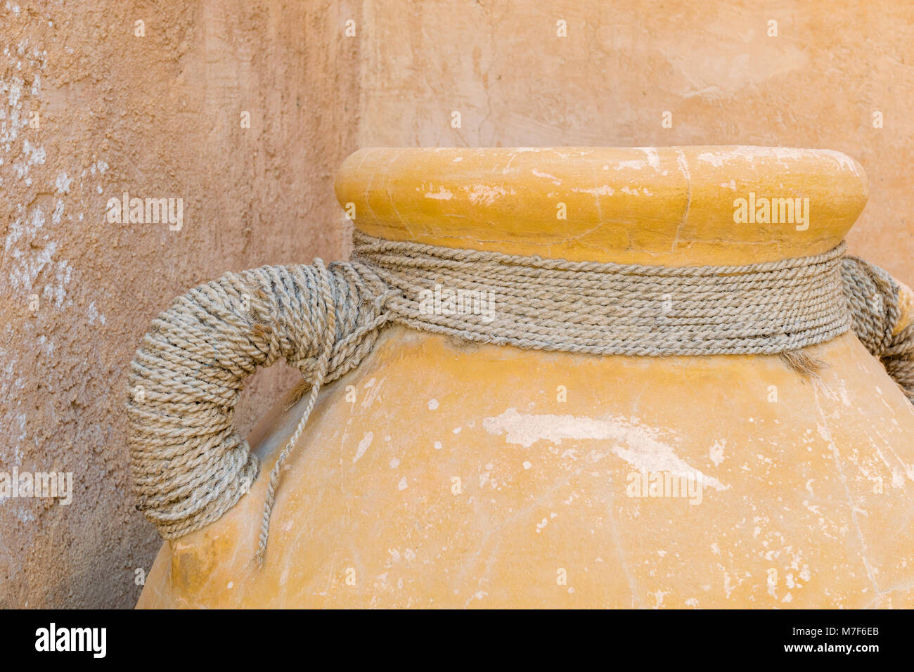 Handle of large arabic style stoneware water storage jug with rope ...