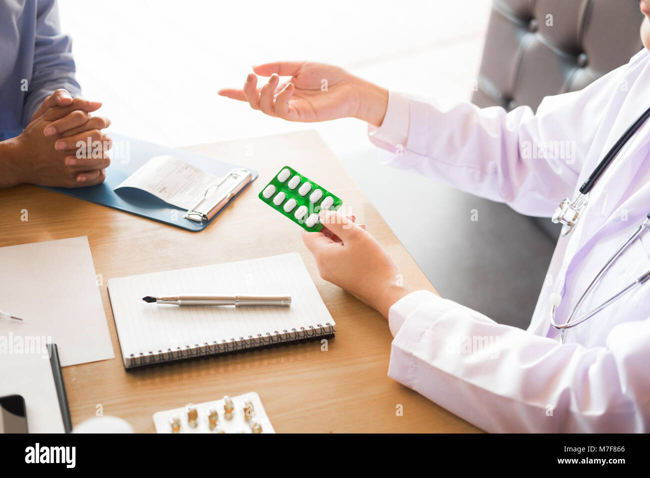 doctor hand holding tablet of drug and explain to patient in hospital ...