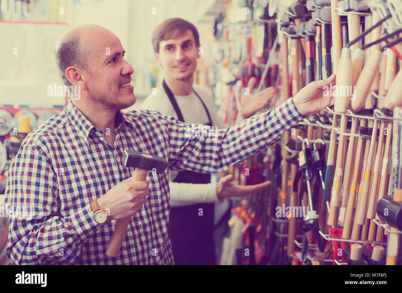 Male client and professional salesman at tooling section in building ...