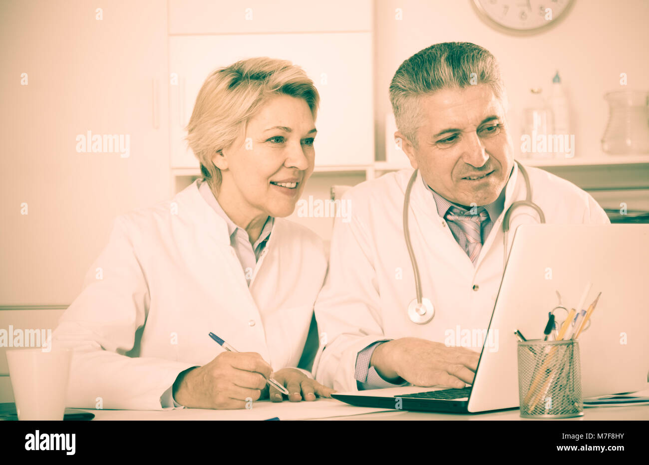 Doctor and nurse reading patient information in hospital computer ...