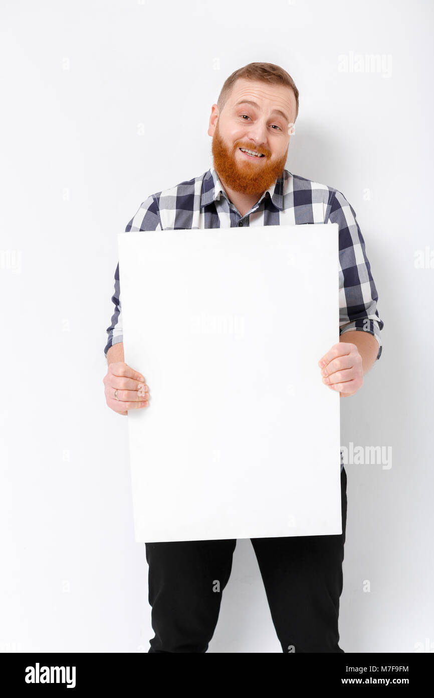 handsome smiling man with beard holding big white card. empty blank ...