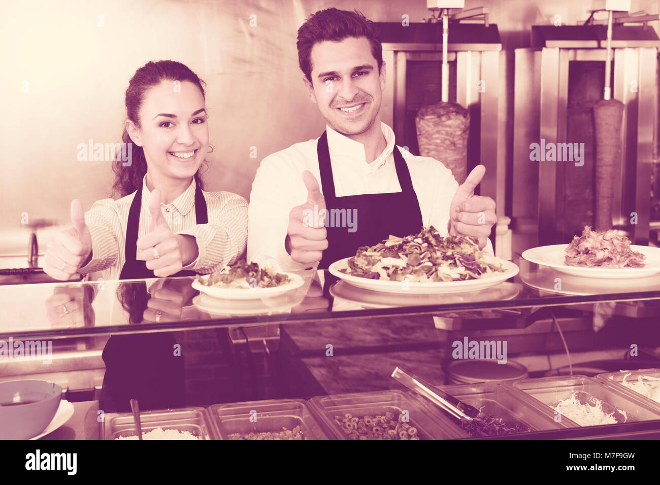 Portrait of two laughing workers with kebab at fastfood place Stock ...