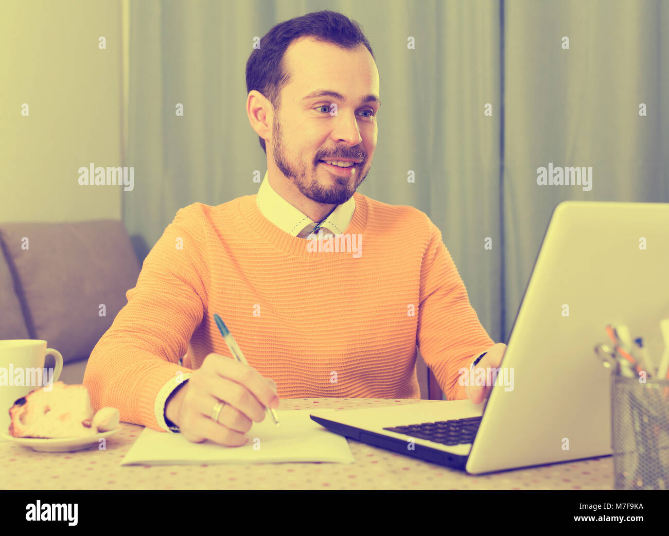 Smiling man learner studying effectively at online courses at home ...