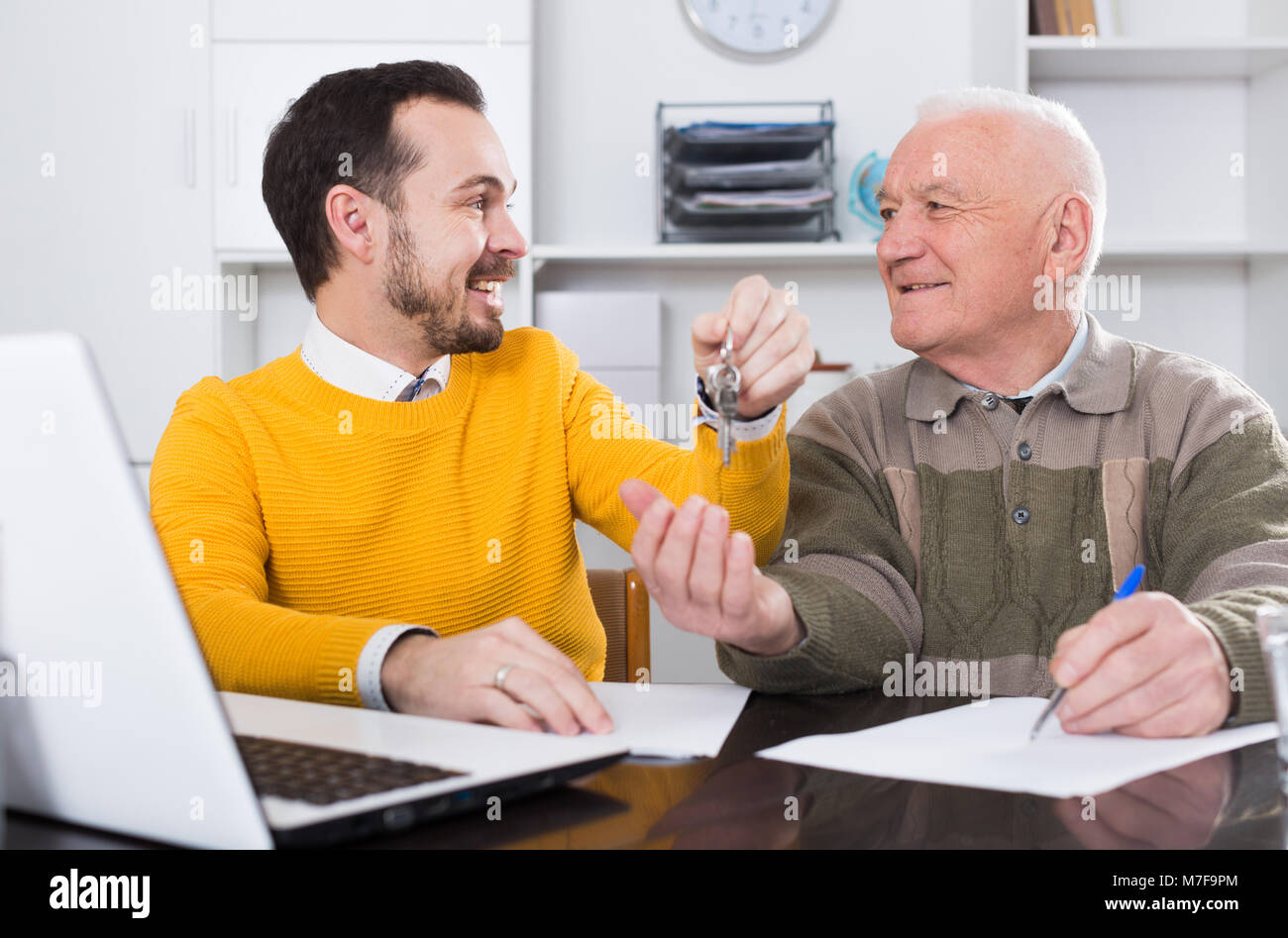 Aged man signing papers for new house in office Stock Photo - Alamy