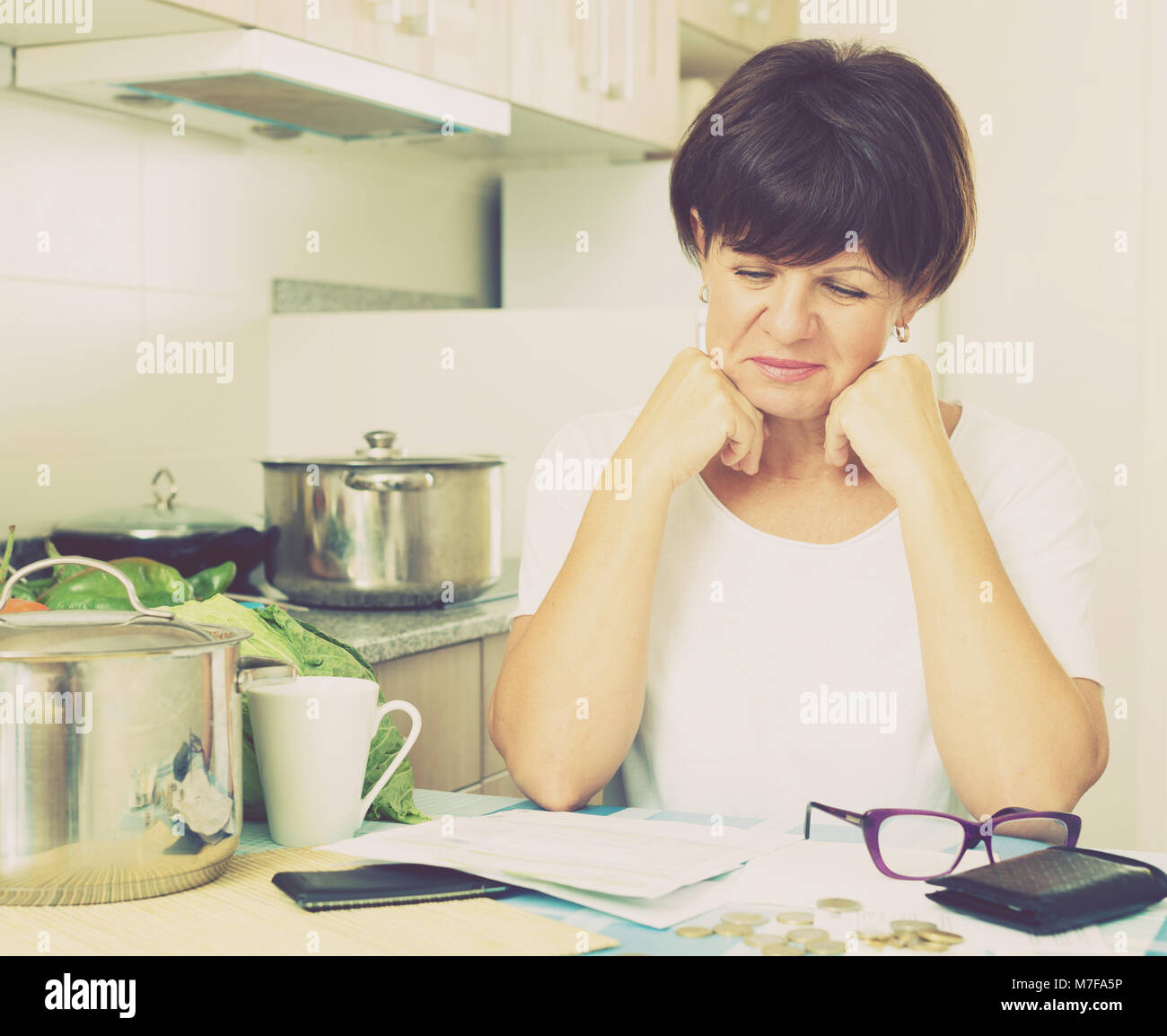 portrait of smiling senior woman bookkeeping bills and payments at her ...
