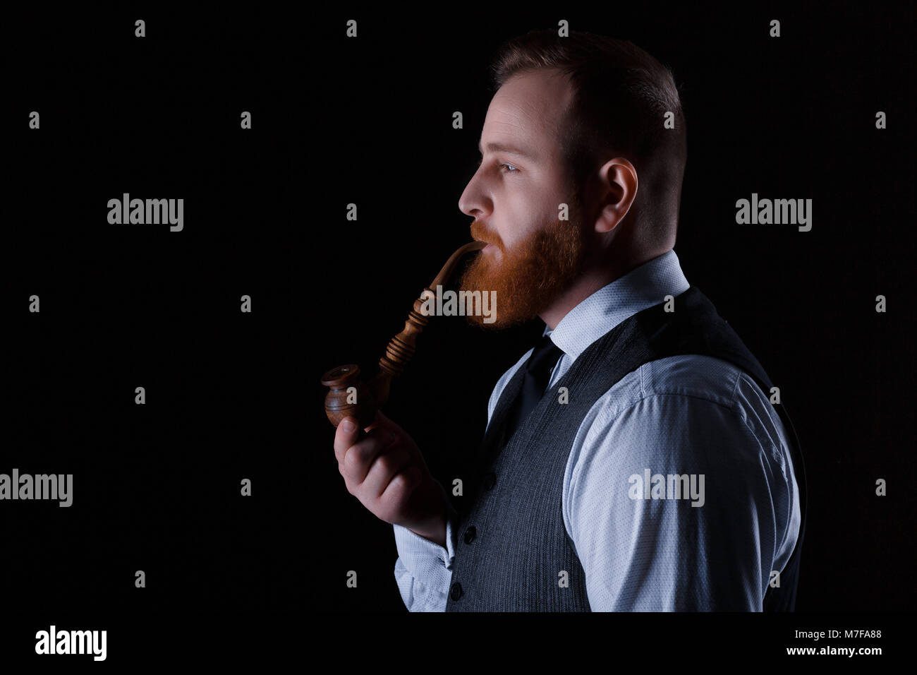 portrait of a red bearded man smoking a pipe on black background Stock ...