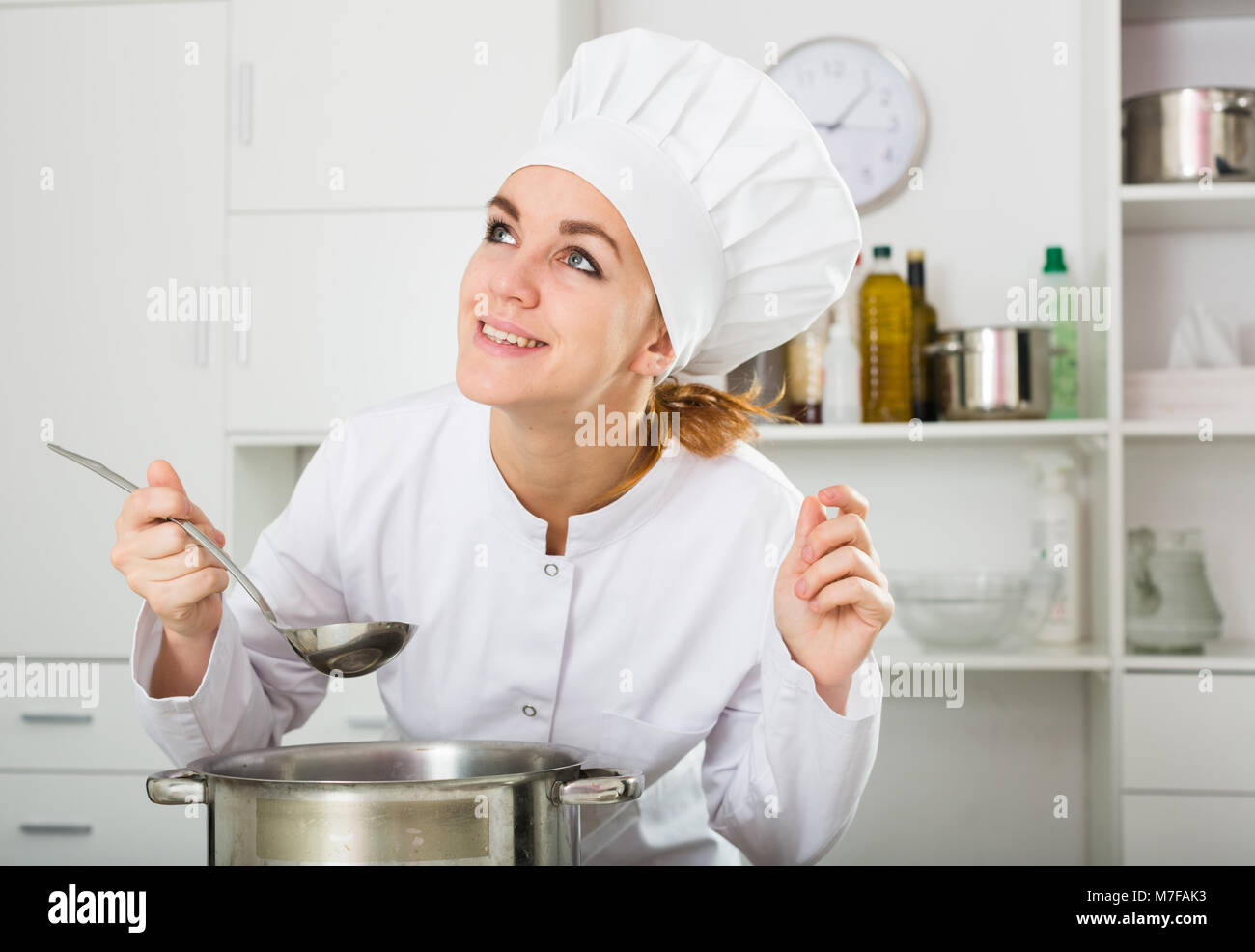 Smiling woman cook tasting delicious dishes in kitchen Stock Photo - Alamy
