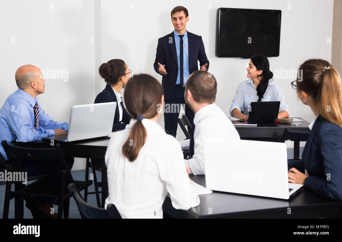 caucasian employee presenting his idea on project to team in office ...