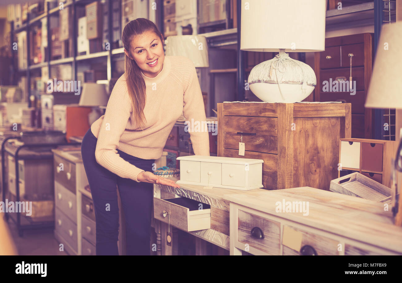 Female choosing wooden table with drawers in the furniture shop Stock ...