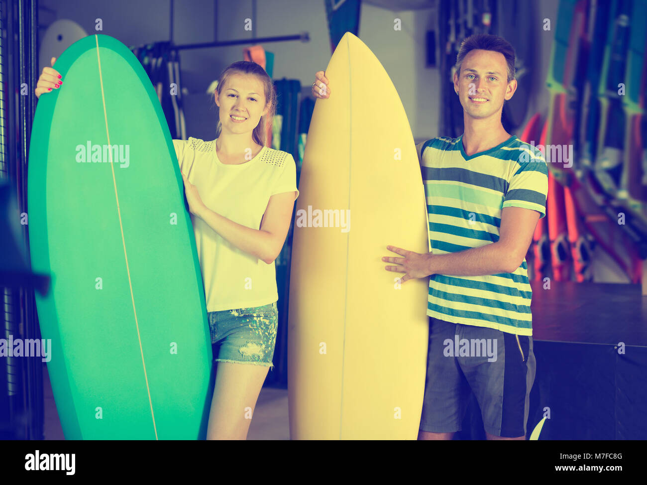Nice couple is showing colorful boards in store on the beach Stock ...
