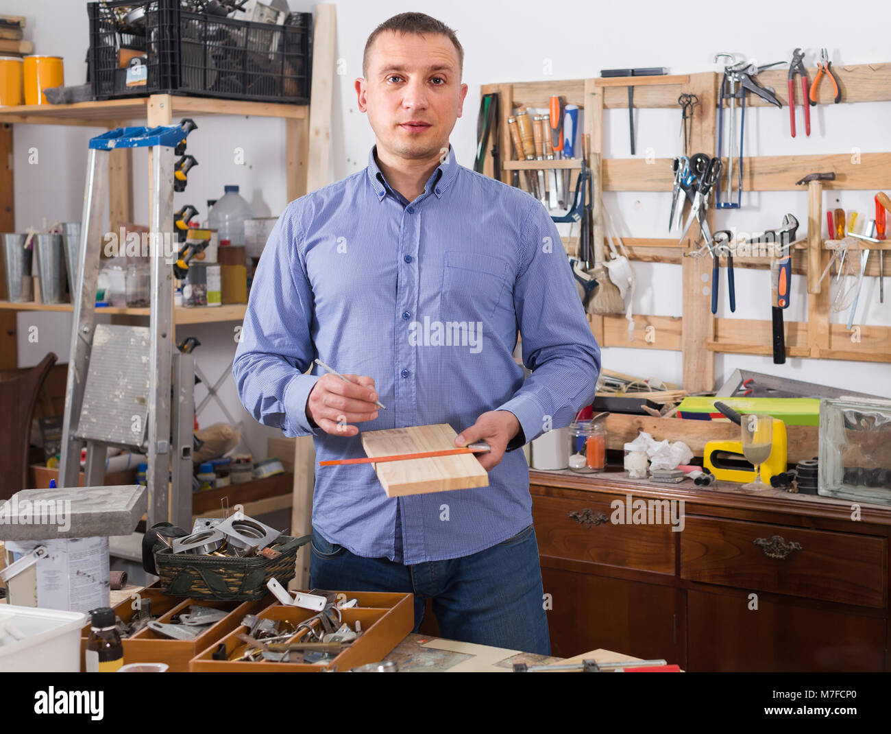 positive adult woodworker working wood plank at workplace Stock Photo ...