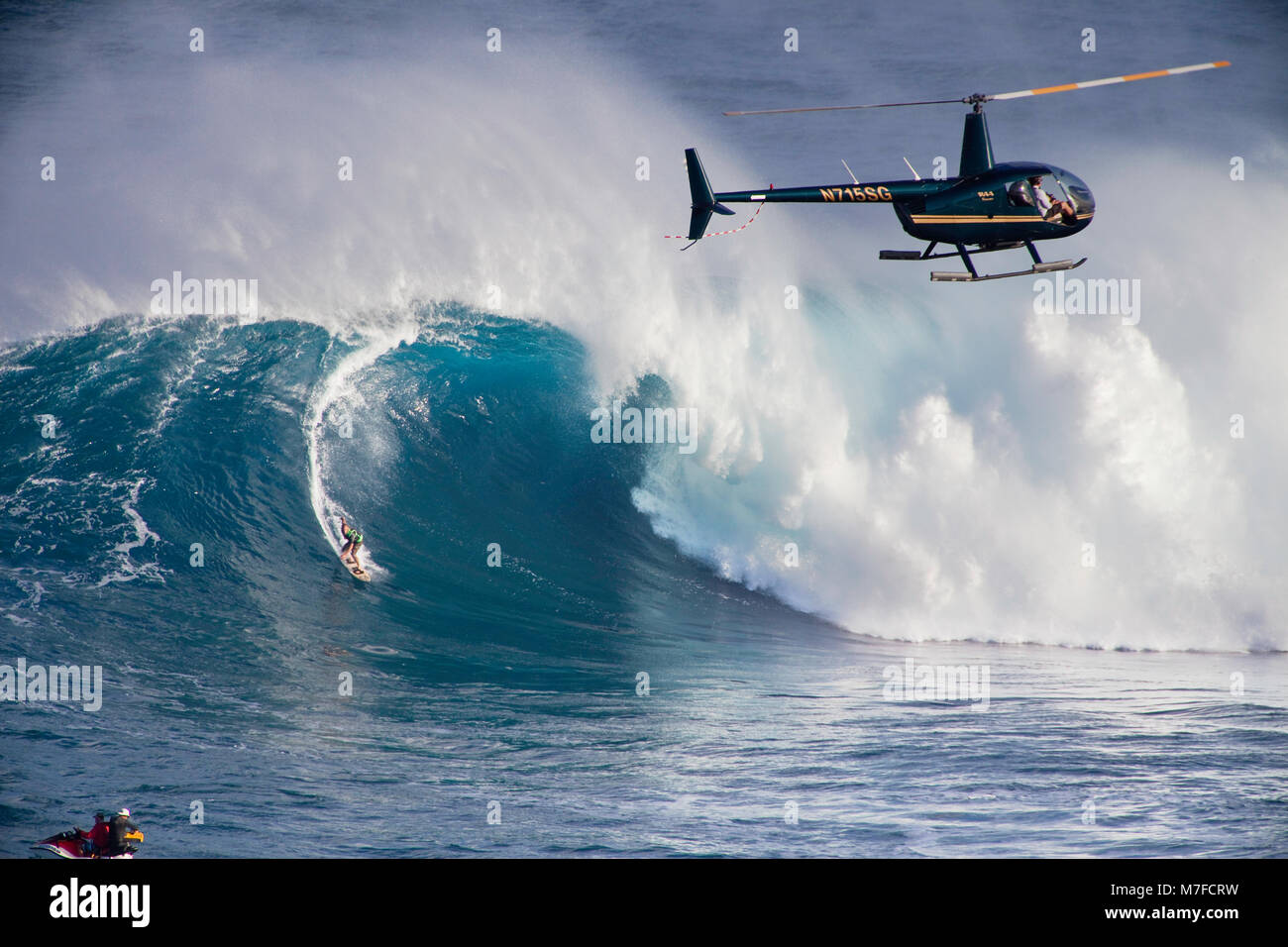 A helicopter filming a tow-in surfer at Peahi (Jaws) off Maui. Hawaii Stock Photo - Alamy