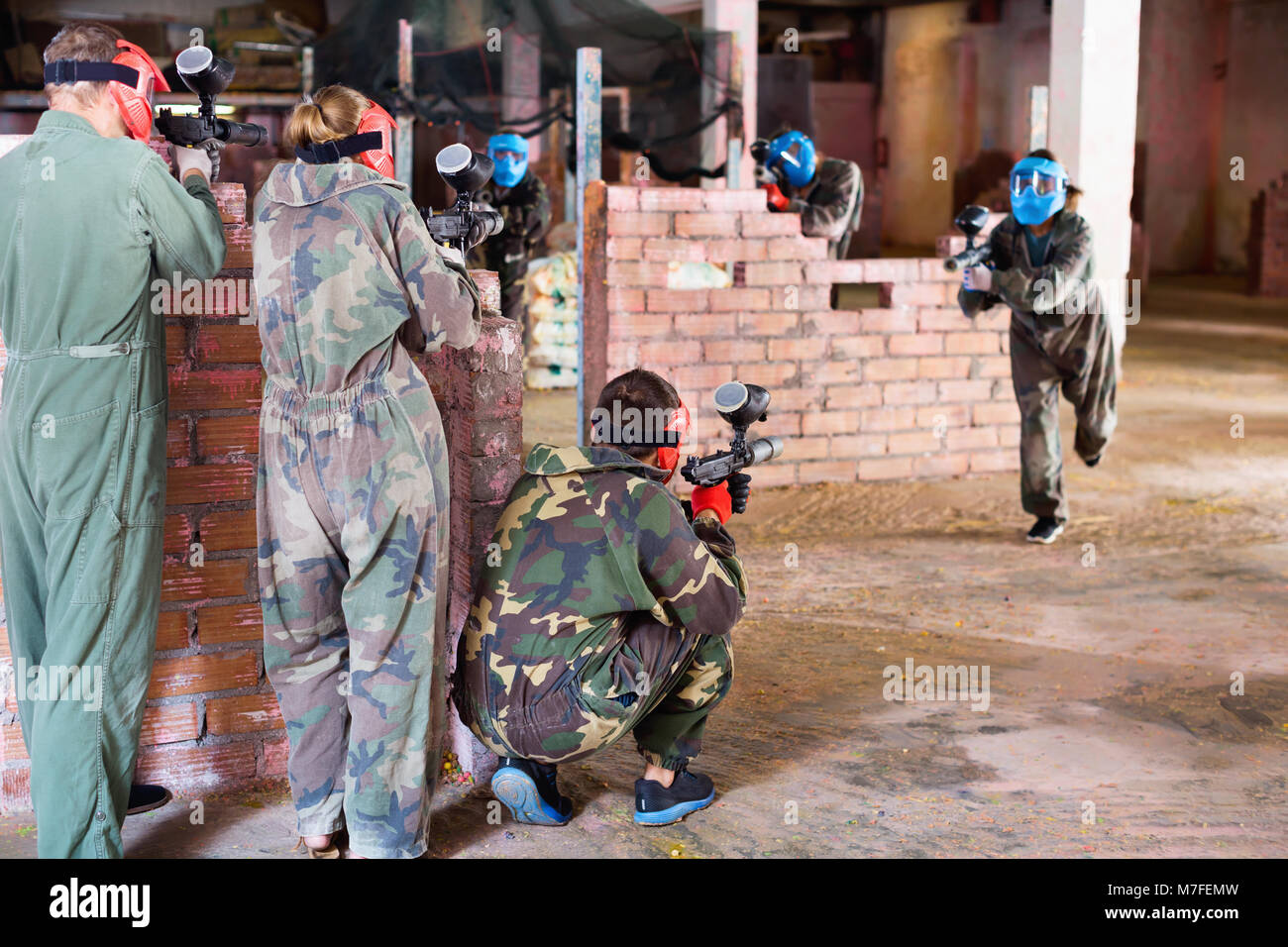Happy cheerful teams faced on the battlefield in the arena of paintball ...