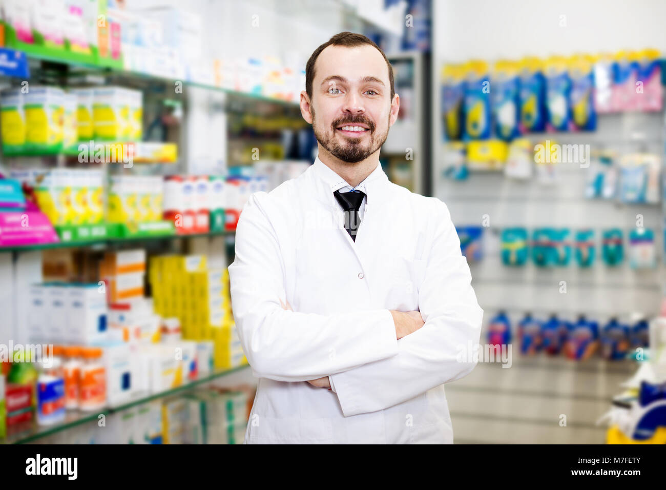 Happy male pharmacist displaying assortment of drugs in pharmacy Stock ...