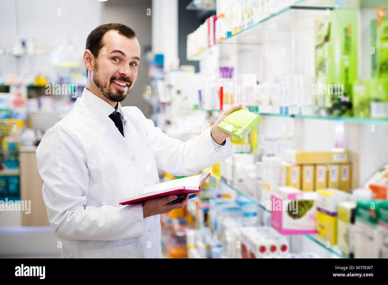 Smiling pharmacist writing down assortment of drugs in pharmacy Stock ...