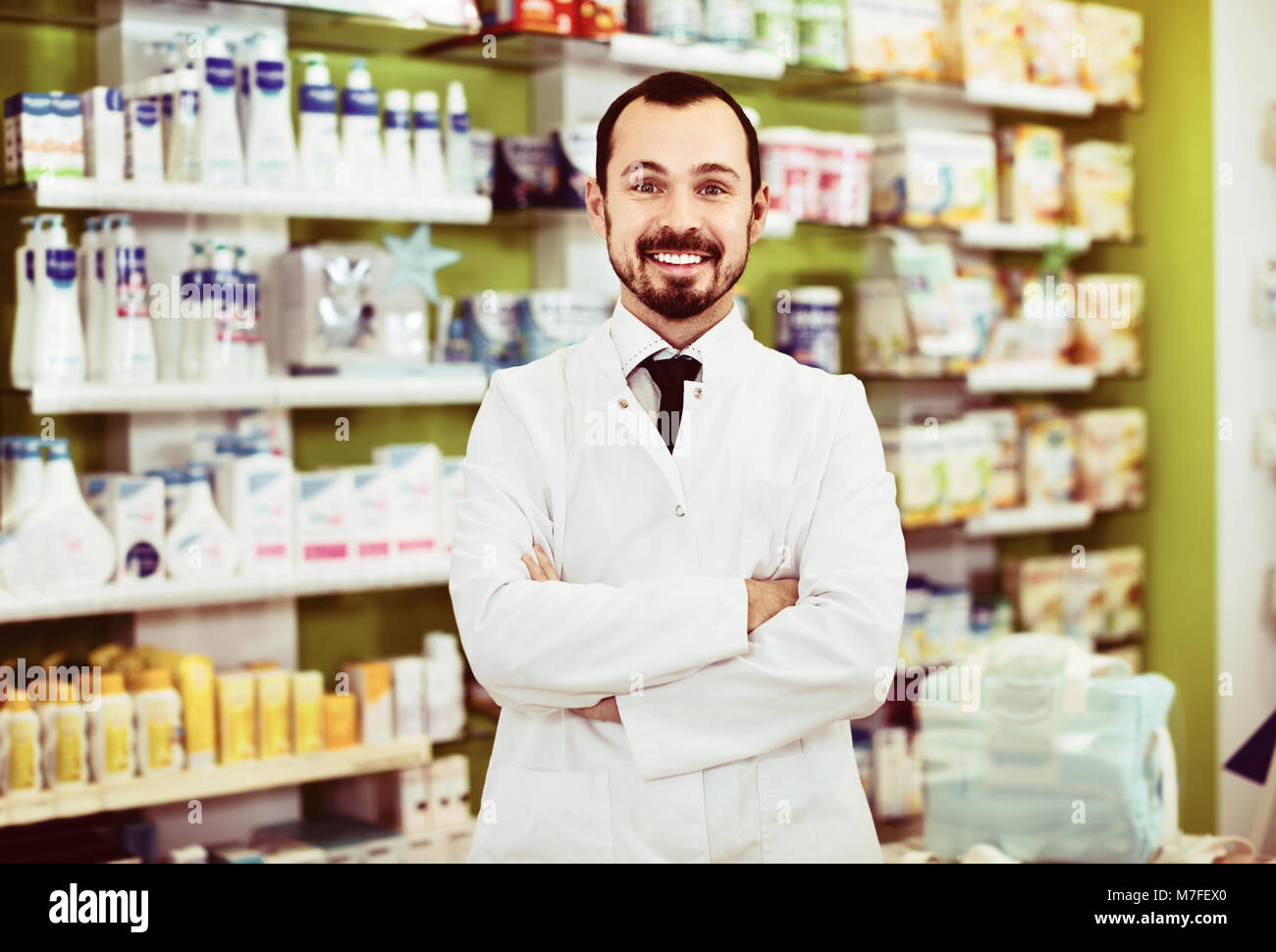 Happy cheerful positive male pharmacist demonstrating assortment of ...