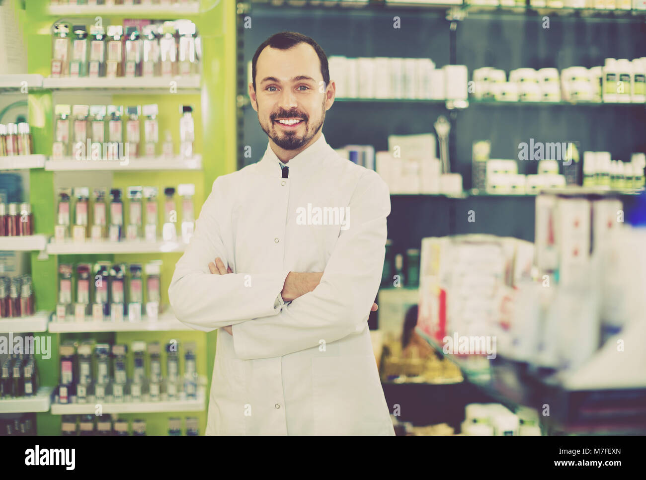 Smiling happy cheerful positive male pharmacist demonstrating ...