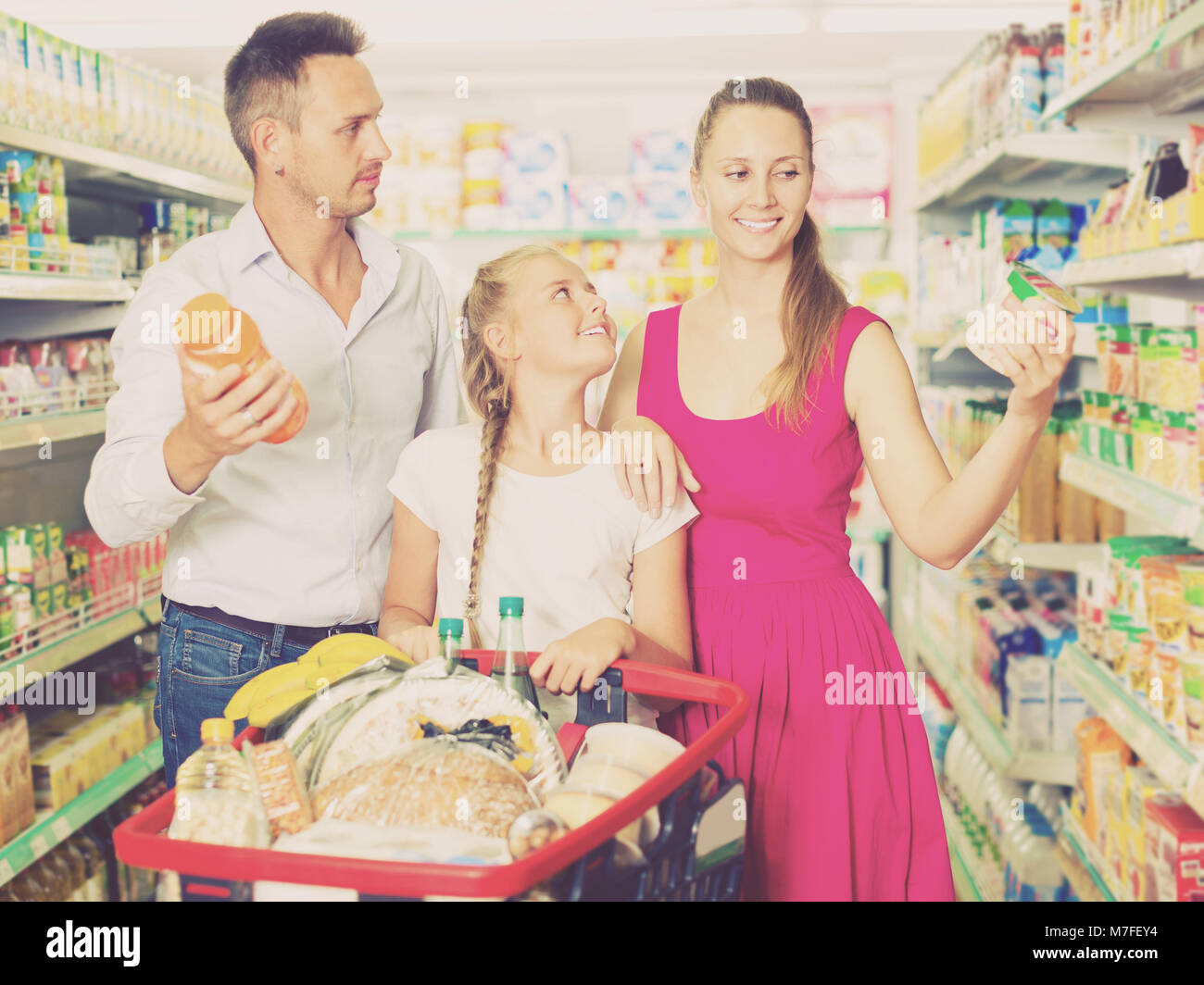 Positive three customers smiling and standing with purchases in ...