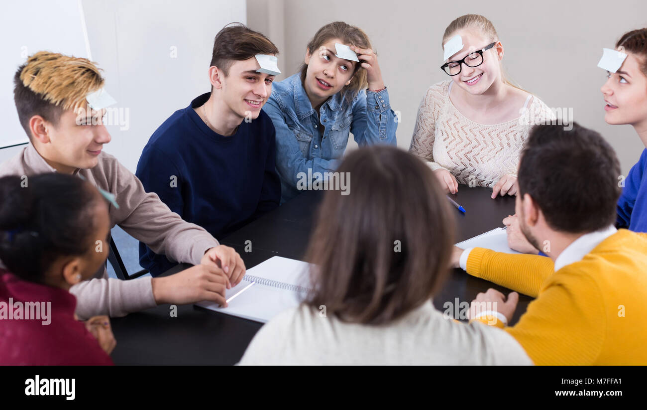 positive american classmates having round of guess-who game during ...