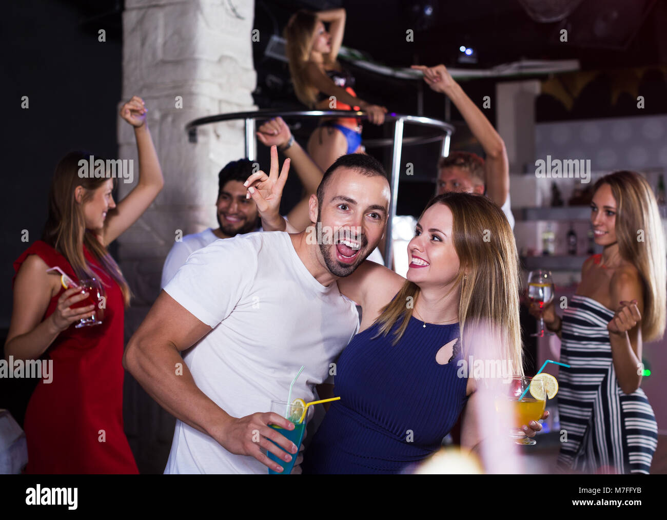 Smiling man and woman dancing and hugging on party in the club with ...