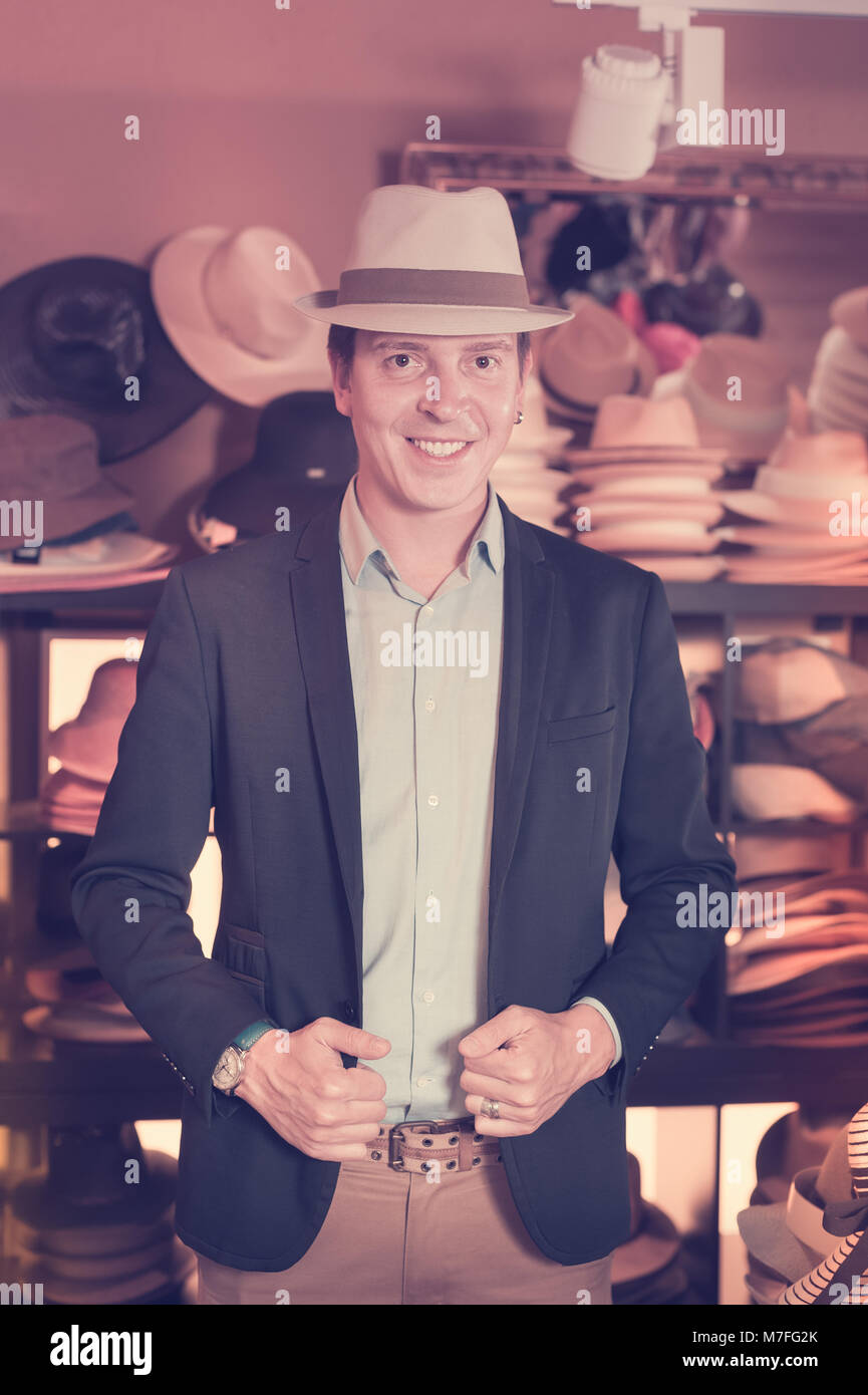 Portrait of positive adult male try on hat at the shopping mall Stock ...