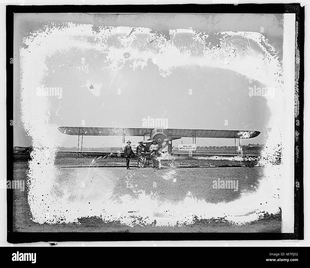 A historical photograph featuring Thos. R. Shipp with an aeroplane ...