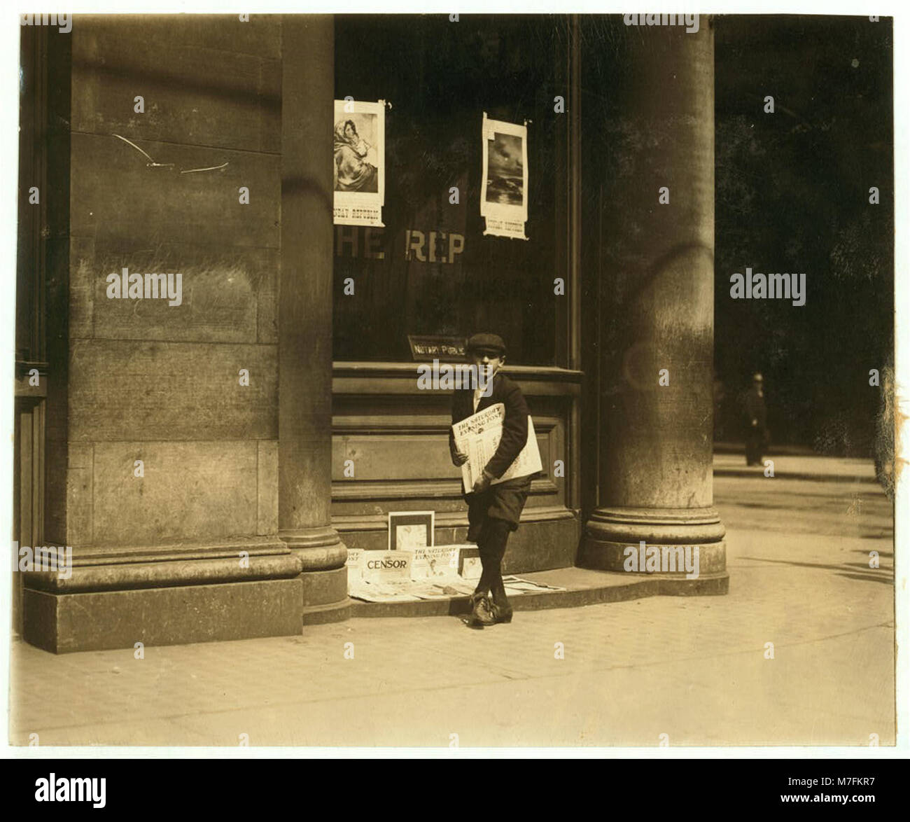This image captures a moment of a truant newsboy at the intersection of ...