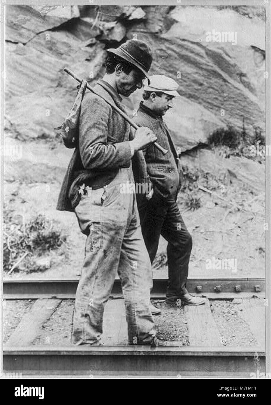 Photograph of two hobos walking along railroad tracks after being ...