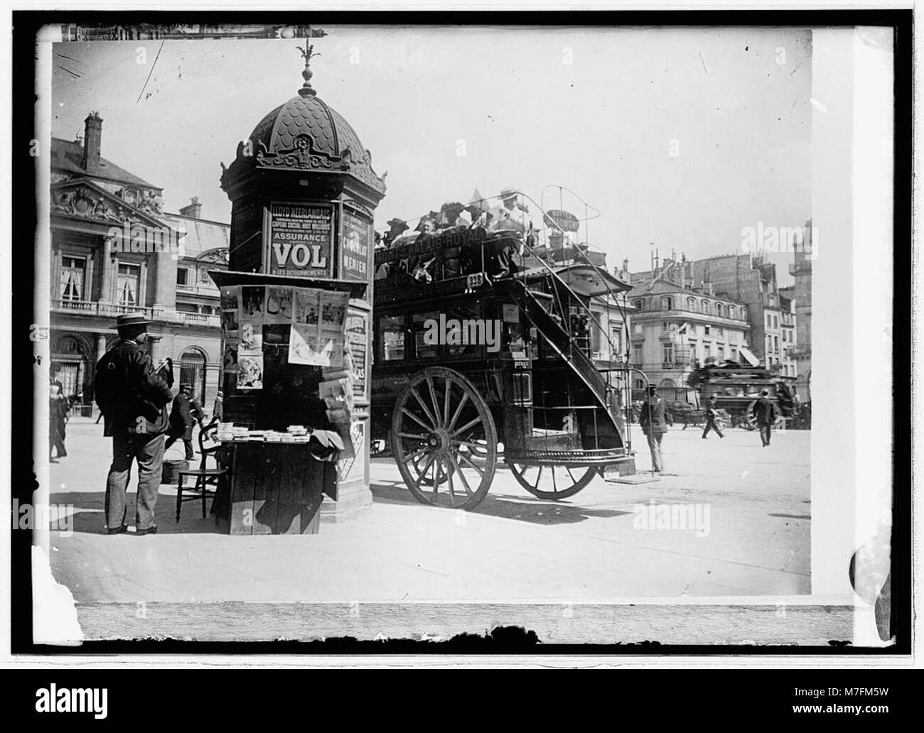 A typical Parisian street corner featuring a kiosk, embodying the ...