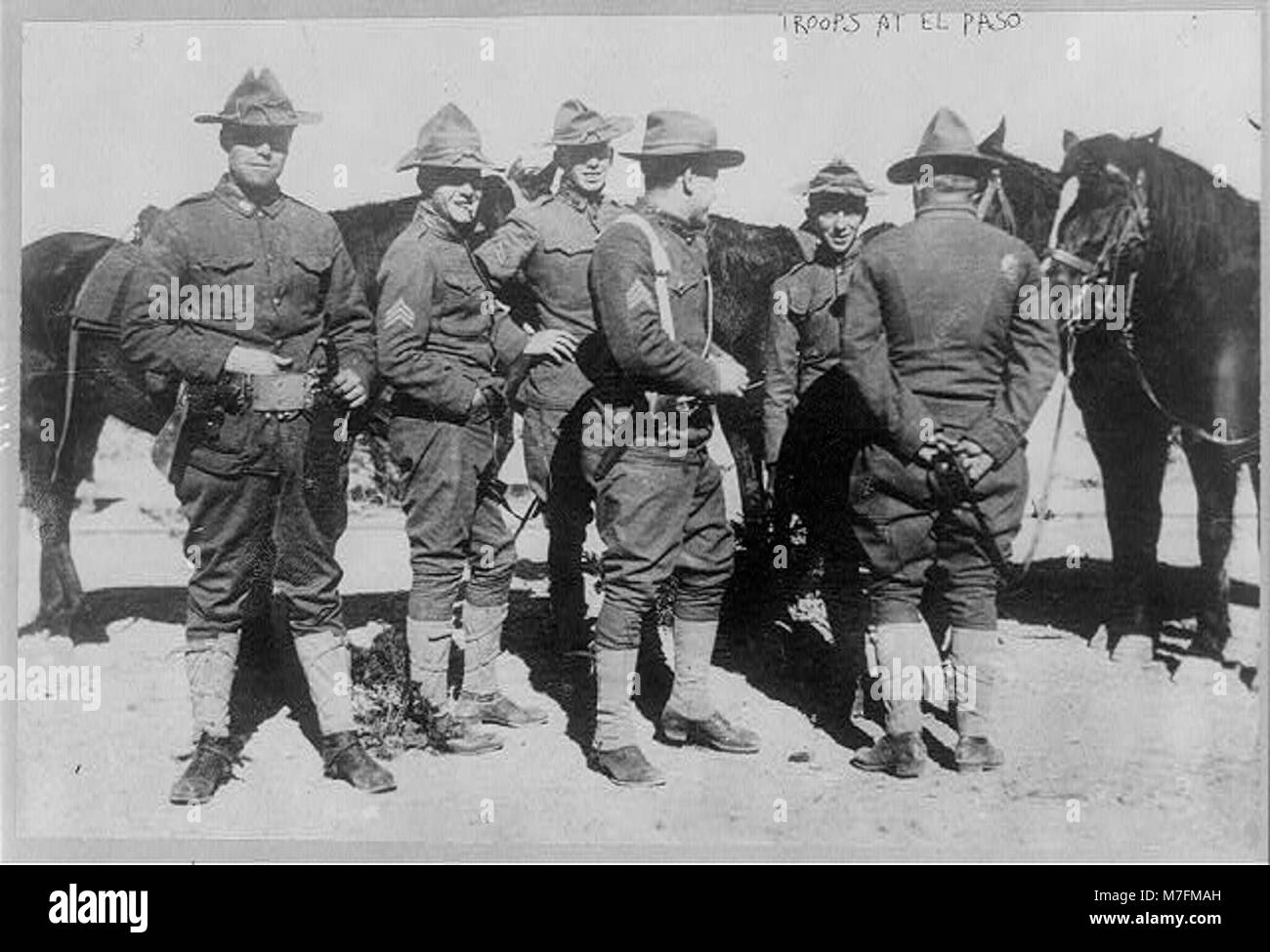 A photograph of U.S. Army cavalrymen standing beside their horses in El ...