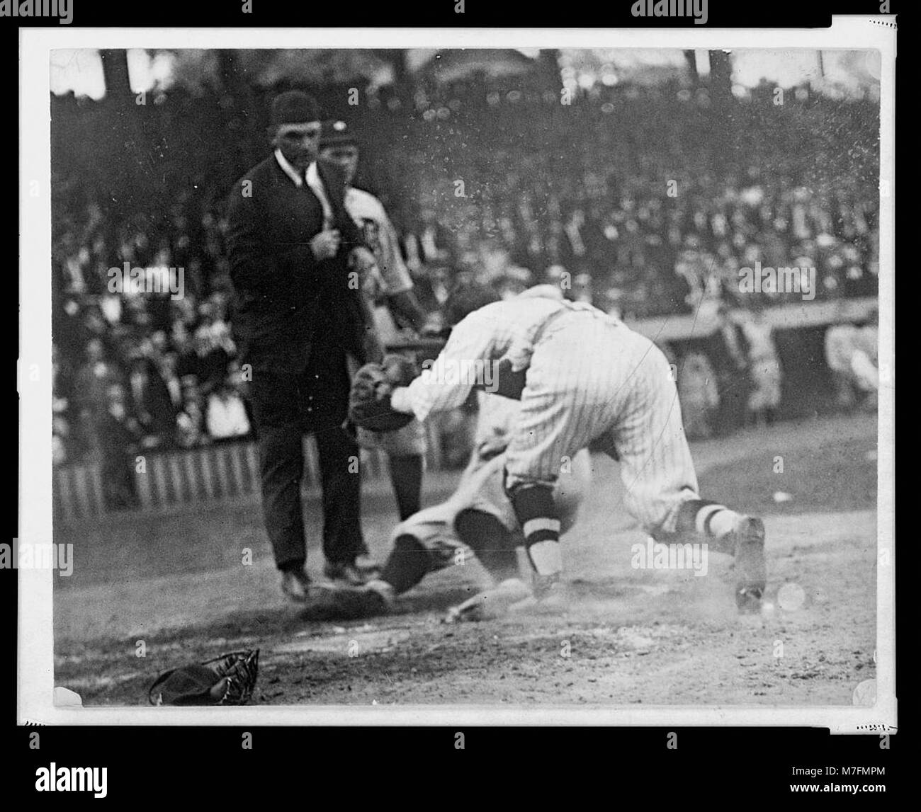Umpire ready to make the call as catcher tags base runner sliding into ...