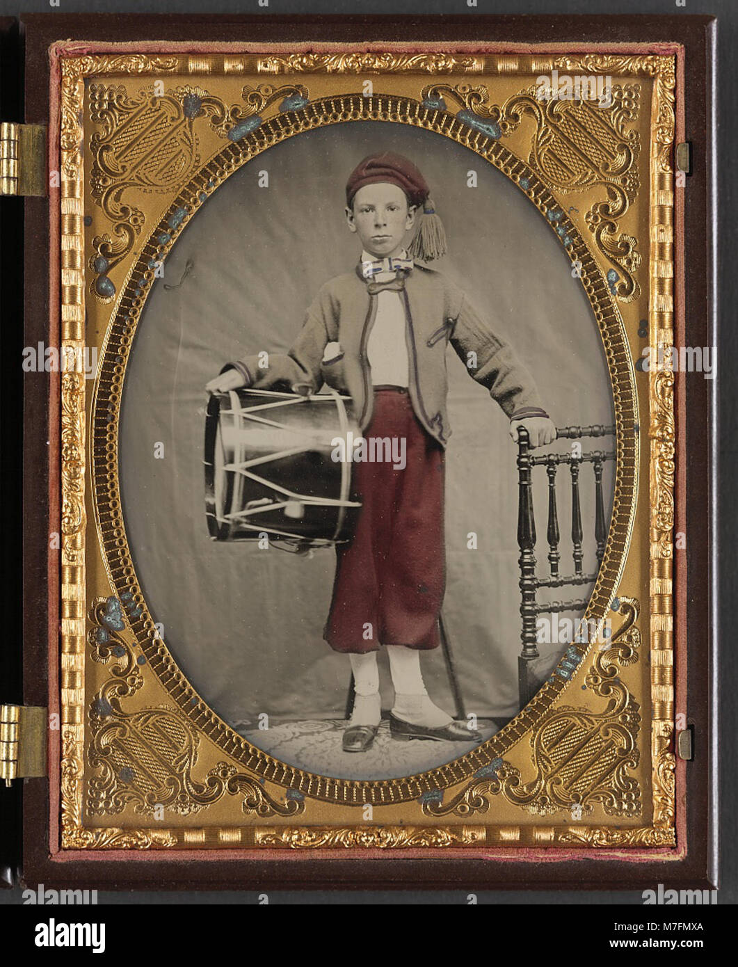 A young boy is depicted wearing a Union Zouave uniform while holding a ...