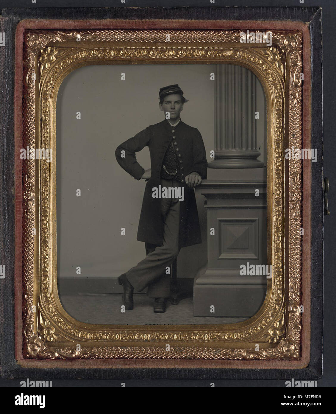 A photograph of an unidentified Union soldier in uniform, standing by a ...