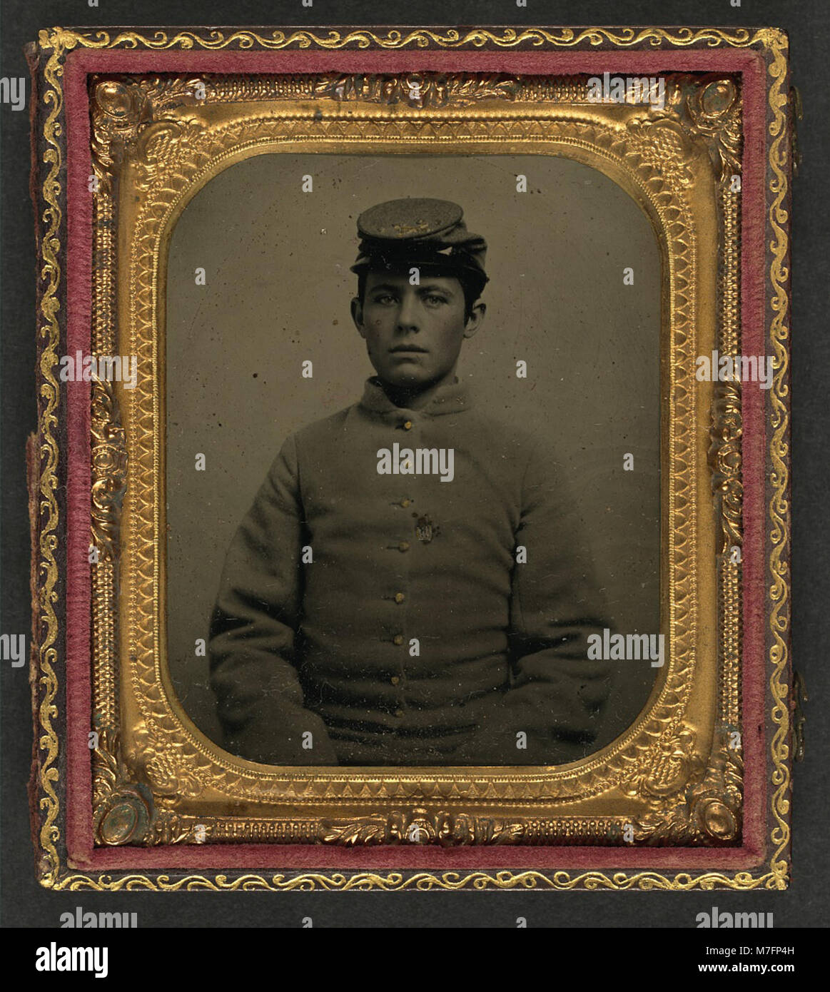 A photograph of an unidentified young Confederate soldier wearing a ...