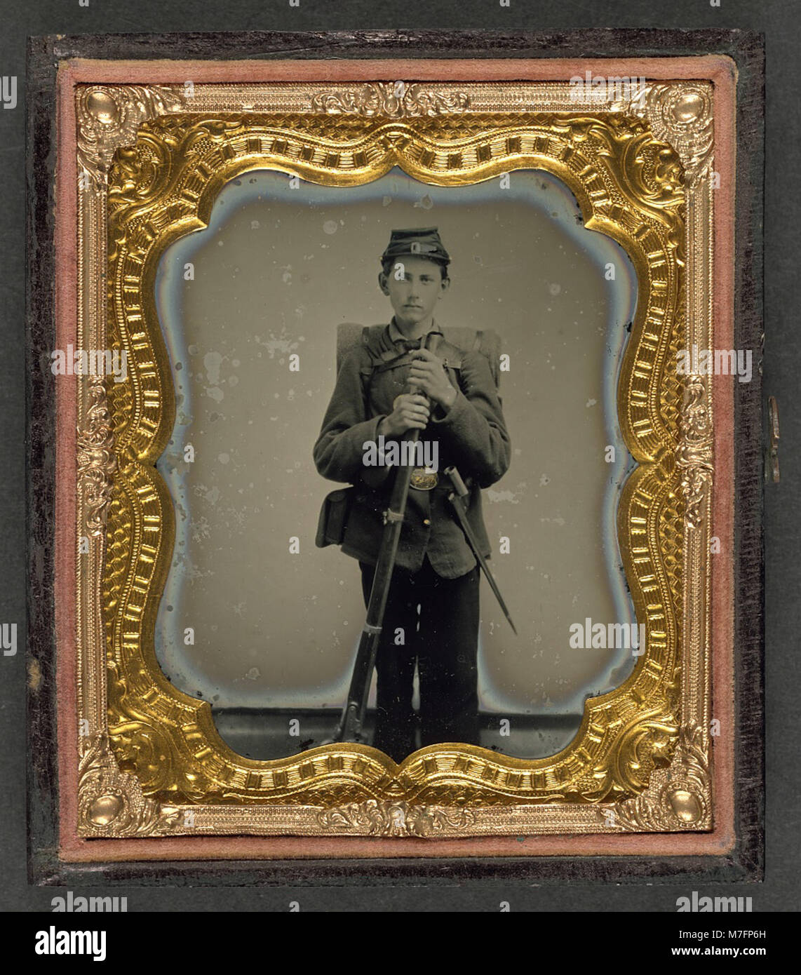 This photograph shows a young soldier in Union uniform, equipped with a ...