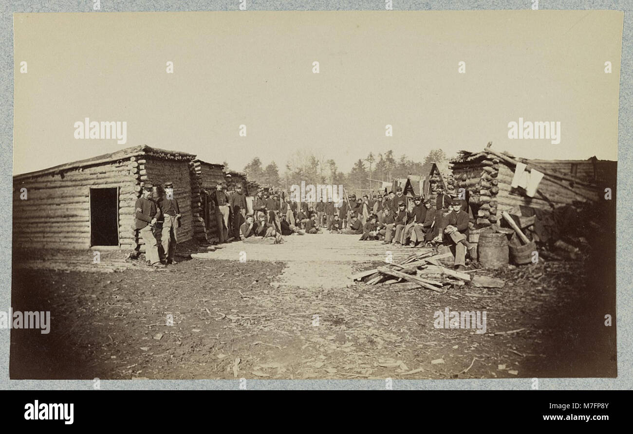 Union soldiers are posed in front of log buildings during the American ...