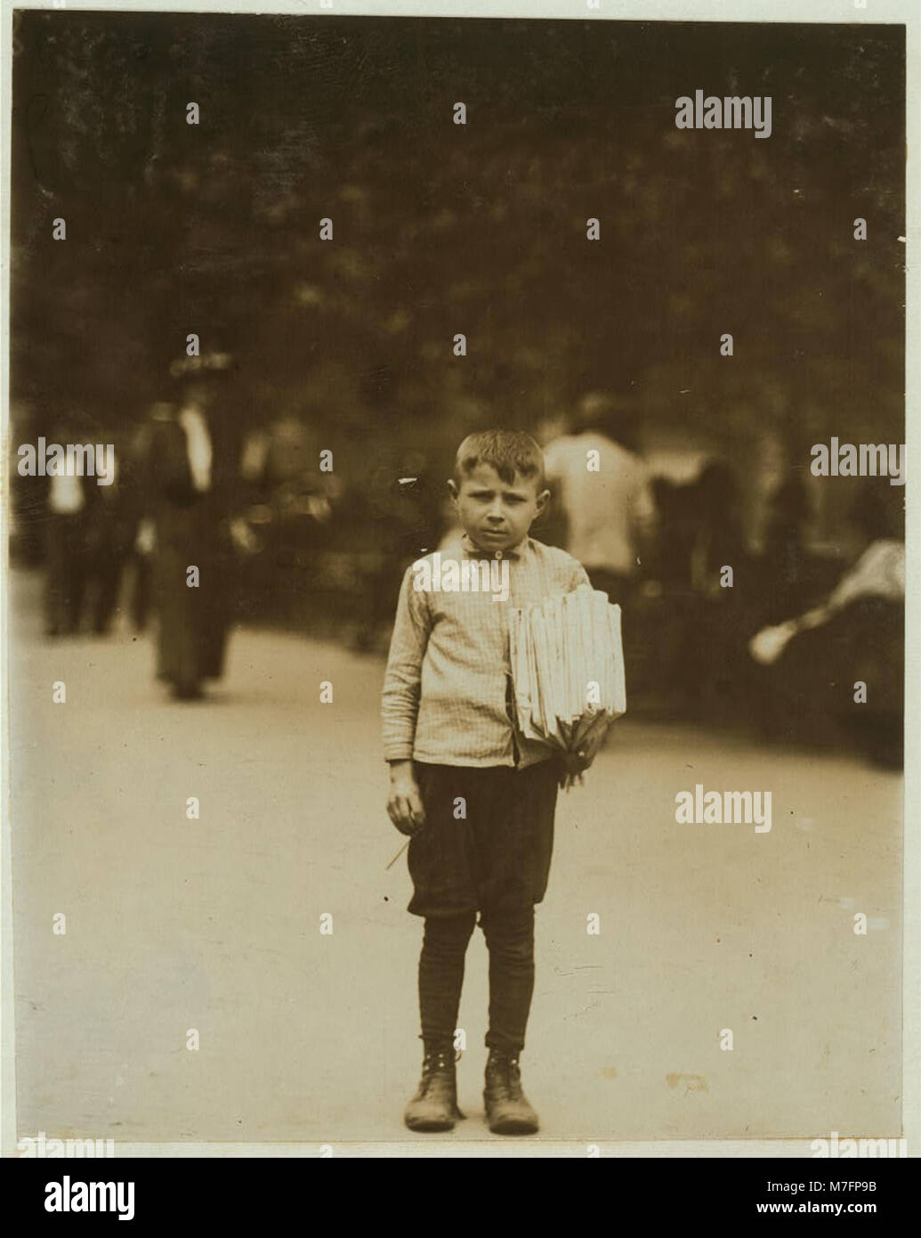 Joseph Blata, a 7-year-old newsboy, is shown collecting discarded ...