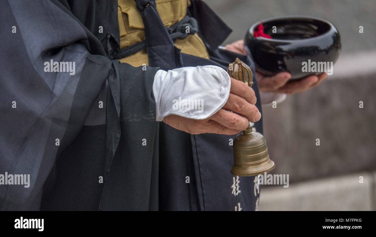 Close up of Japanese Buddhist pilgrim wearing black robes and white ...