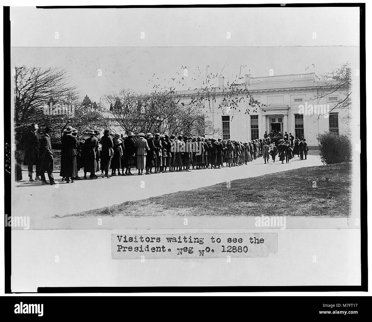 A group of visitors waits in line to meet the president, reflecting the ...