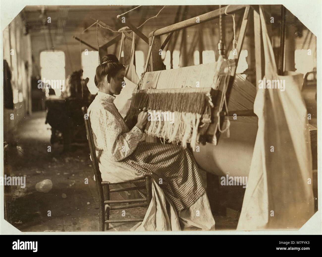 A photograph of a woman working at a beam warper in Cherryville, North ...