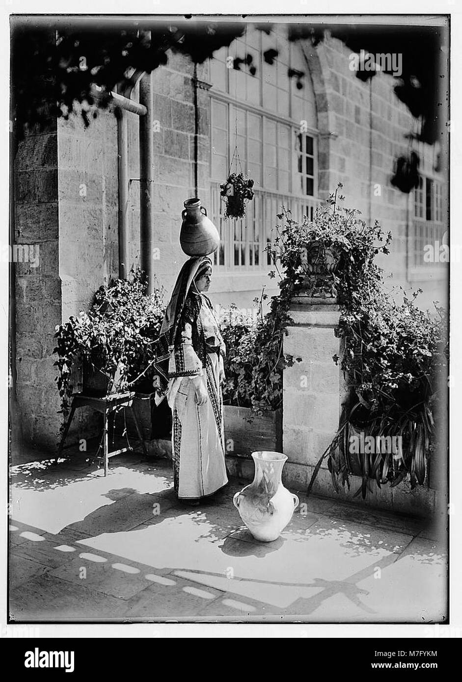 A photograph of a woman from Ramallah standing in the courtyard of the ...